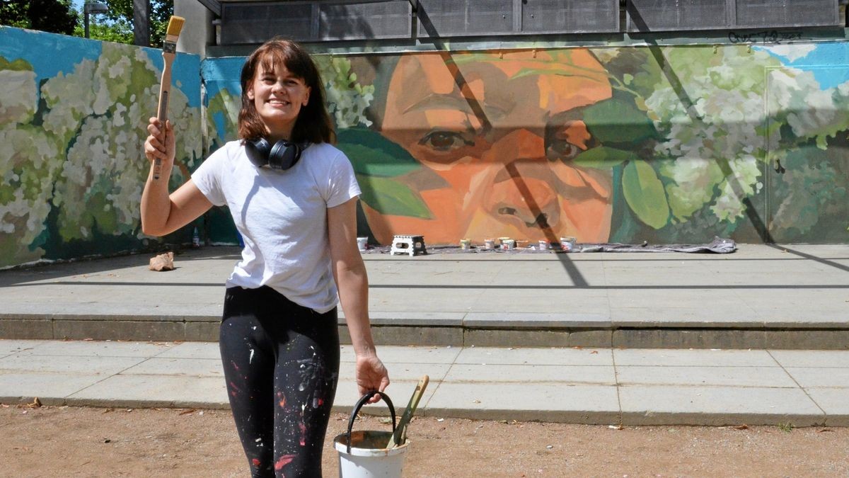 Frau schaut im Brühler Garten von Erfurt durch blühende Zweige