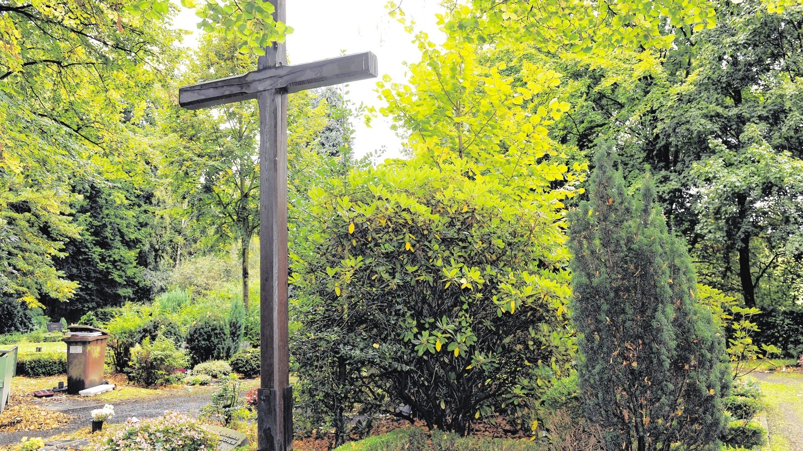 Ein Kreuz mit dem Friedhof